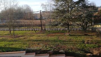 Um parque com um calçadão pavimentado, árvores e um banco.