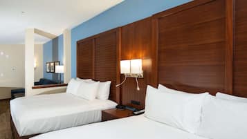 Quarto de hotel com duas camas, cabeceiras de madeira e luminárias de cabeceira.