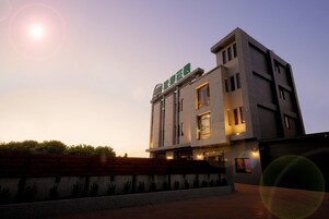 Um edifício moderno com uma placa que diz 'Green Hotel'.