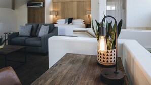 Uma sala de estar moderna e bem iluminada, com um sofá, uma mesa de centro e uma planta decorativa.