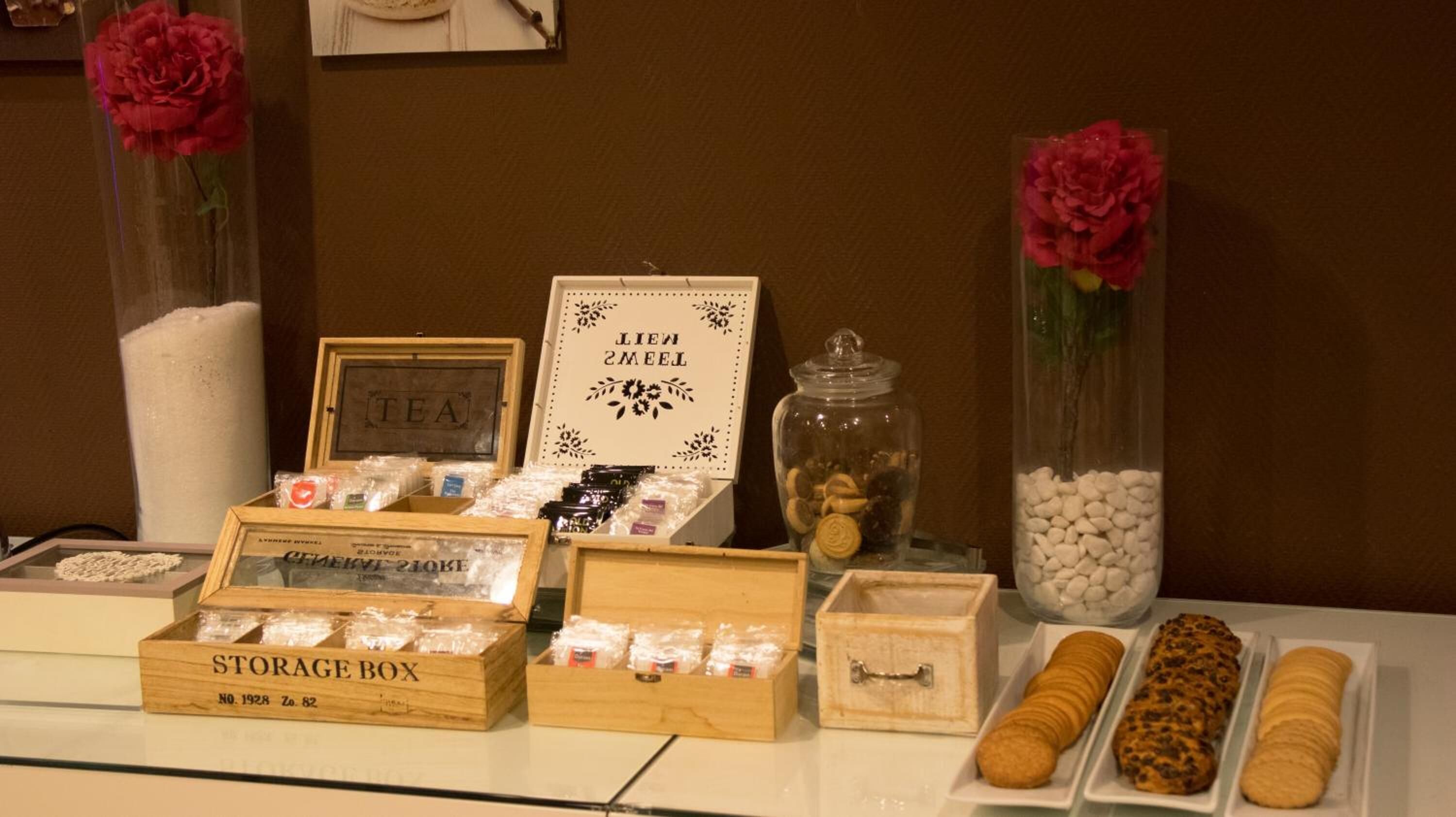 Exposição de diversos produtos embalados, incluindo uma caixa de armazenamento com a etiqueta 'STORAGE BOX', um pote com pedras brancas e várias caixas de biscoitos.