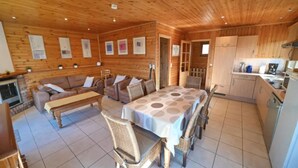 Uma cabana aconchegante com sala de estar, sala de jantar e cozinha.