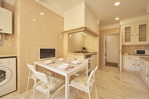 Um frigorífico/congelador grande, um micro-ondas, uma placa de cozinha 