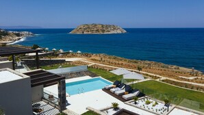 Área da piscina com vista para o mar e uma pequena ilha.