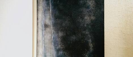 Uma pintura abstrata em preto e branco exposta em uma parede.