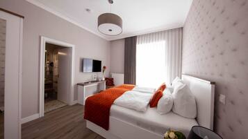 Quarto de hotel moderno com cama, televisão, mesa de cabeceira e vista para o exterior.