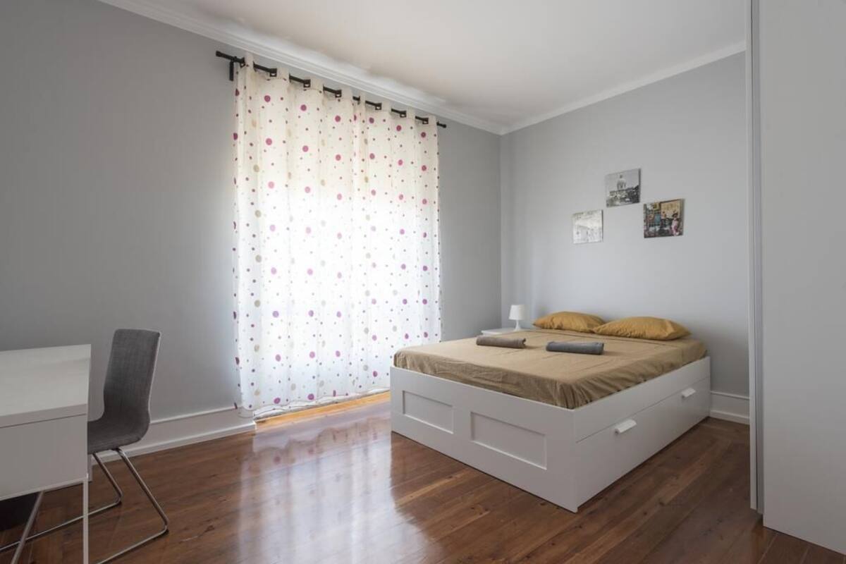 Quarto com cama, escrivaninha e cadeira.