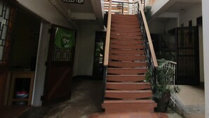 Escadaria que leva a uma área de recepção, com uma placa em cima.