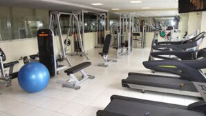 Academia com esteiras, bolas de exercício e aparelhos de musculação.