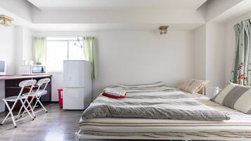 Um quarto com uma cama, uma escrivaninha e uma cadeira.