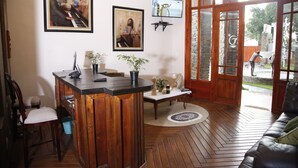 Uma sala de estar aconchegante com um espaço de bar em madeira, um sofá confortável e uma televisão.