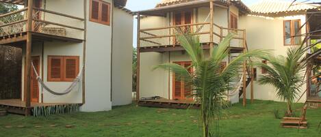 Um edifício de dois andares com uma varanda e uma rede.