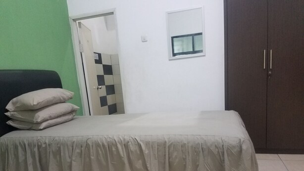 Quarto com cama, guarda-roupa, uma pequena janela e porta que dá para outro cômodo.