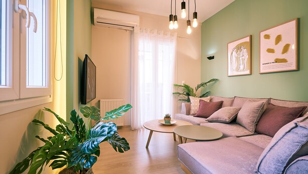 Sala de estar com sofá, mesa de centro e plantas em vasos.