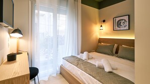 Quarto bem arrumado com cama, mesa de cabeceira, luminária e um quadro na parede.