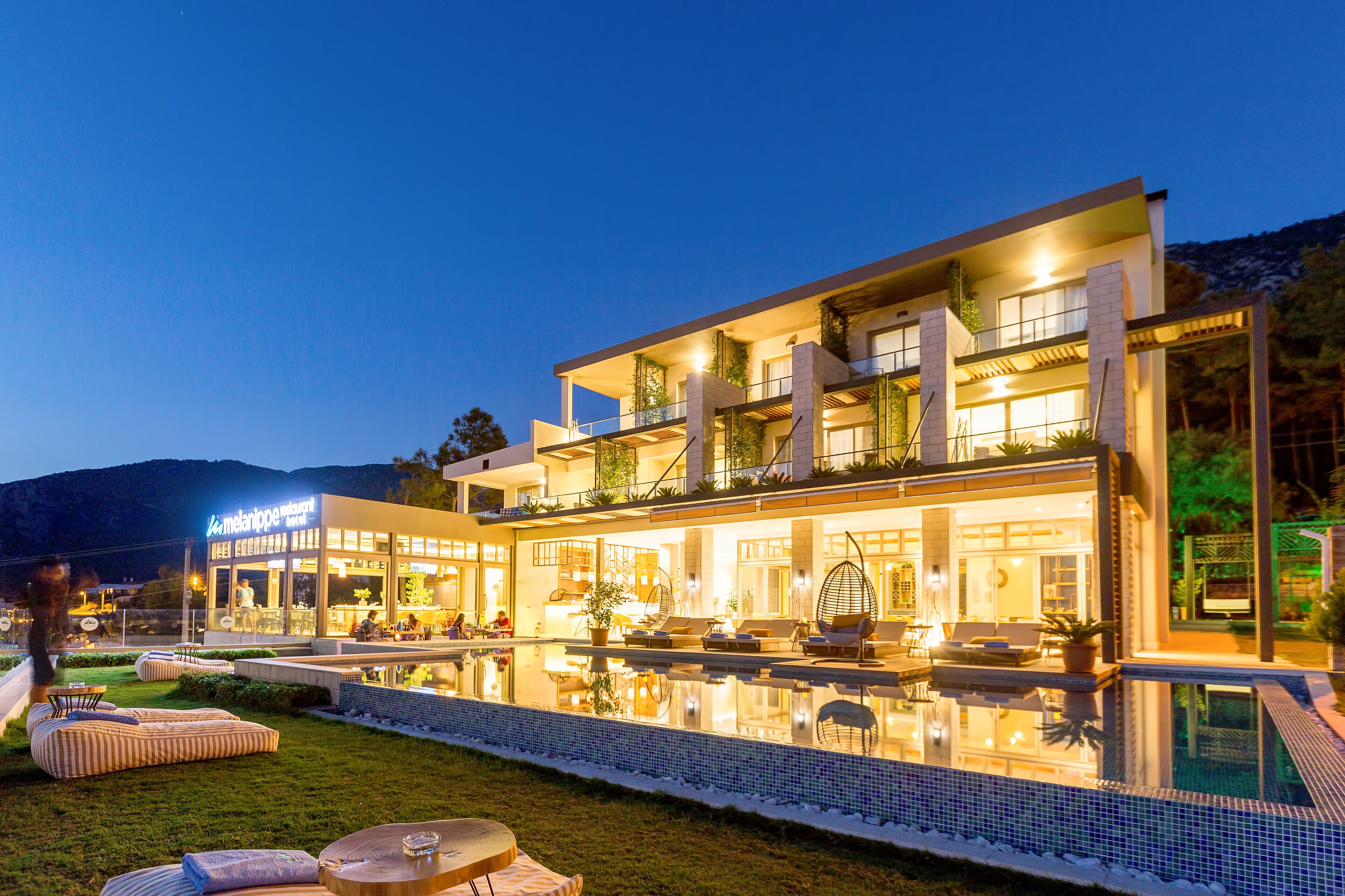 Um hotel moderno com piscina, área de estar externa e restaurante.
