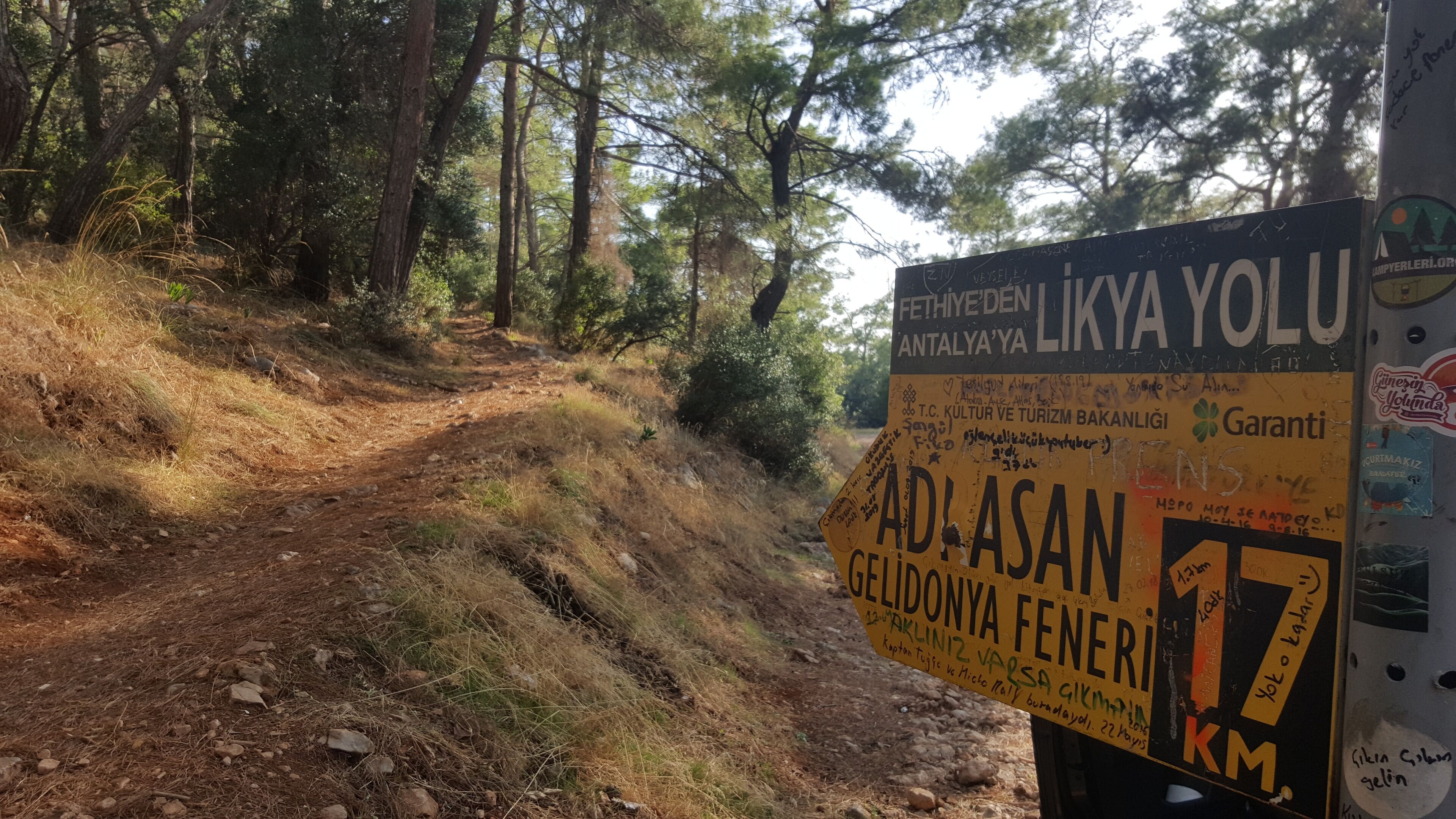 Uma trilha de terra com um sinalizador indicando uma distância de 7 km.