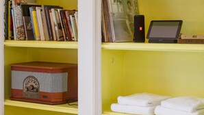 Uma estante com livros, um rádio e um laptop.