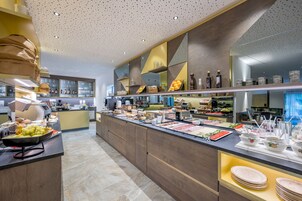 Disposição de buffet com diversos alimentos e utensílios.