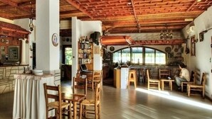 Um interior rústico com vigas de madeira, um espaço de bar e área de estar.