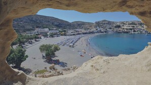 Uma praia com vista clara para o mar e uma cidade ao fundo.