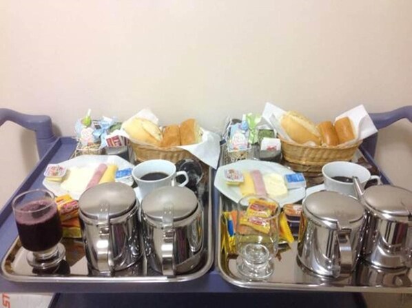 Uma bandeja com itens de café da manhã, incluindo pão, ovos, manteiga e café.