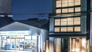 Um edifício moderno com vários andares, grandes janelas e entrada visível.