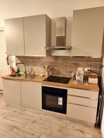 Apartamento Superior | Cozinha privada | Um micro-ondas no espaço comum, uma placa de cozinha 