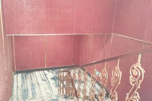 Uma escadaria com corrimão de metal e piso estampado.