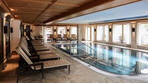 Uma área de piscina com espreguiçadeiras e piscina envidraçada.