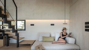 Um interior moderno com um sofá, uma escada e um tablet.