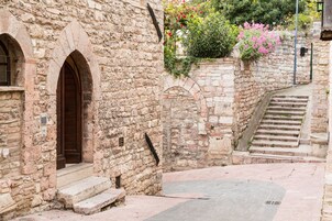 Edifício de pedra com porta de madeira e degraus que levam a um nível superior.
