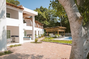 Um edifício moderno com piscina, área de estar externa e vegetação exuberante.