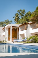 Um resort moderno com piscina, espreguiçadeiras e uma porta de madeira.