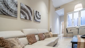 Uma sala de estar moderna com um sofá, uma mesa de jantar e arte abstrata na parede.