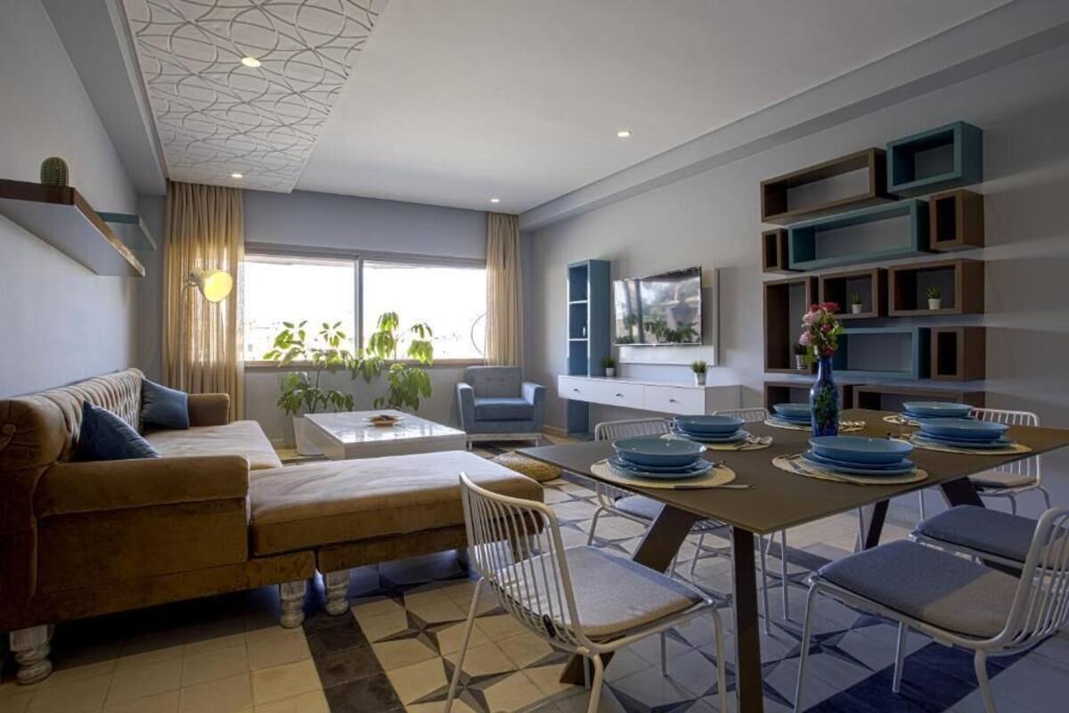 Uma sala de estar moderna com sofá, mesa de jantar, cadeiras e estantes embutidas.