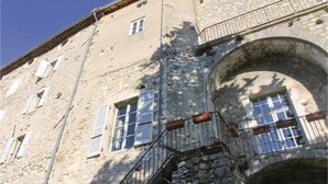 Um edifício de pedra com janelas em arco e varanda.