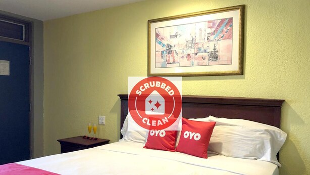 Quarto de hotel com cama, mesa de cabeceira e quadro na parede.