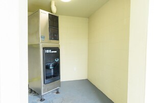 Quarto compacto com dispensador de água e aquecedor fixado na parede.