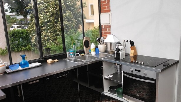 Uma cozinha moderna com uma janela ampla, eletrodomésticos de aço inoxidável e vista para o exterior.