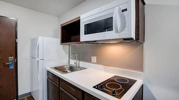 Um frigorífico/congelador grande, um micro-ondas, uma placa de cozinha