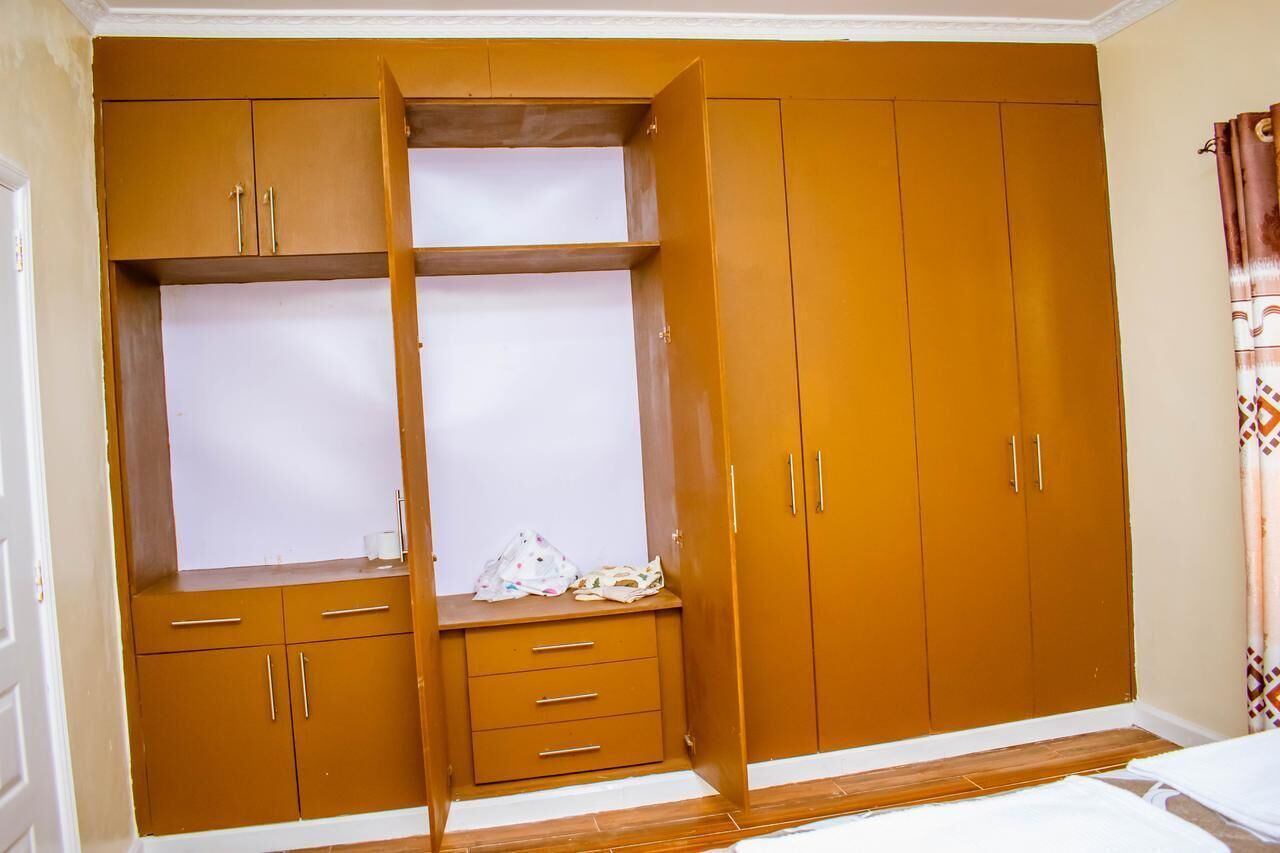 Quarto com guarda-roupa, cama e mesa de cabeceira.