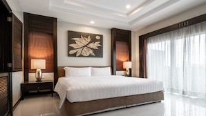 Quarto de hotel moderno com uma cama grande, duas mesas de cabeceira com luminárias, uma janela ampla com cortinas leves e uma obra de arte na parede com padrão de folhas.