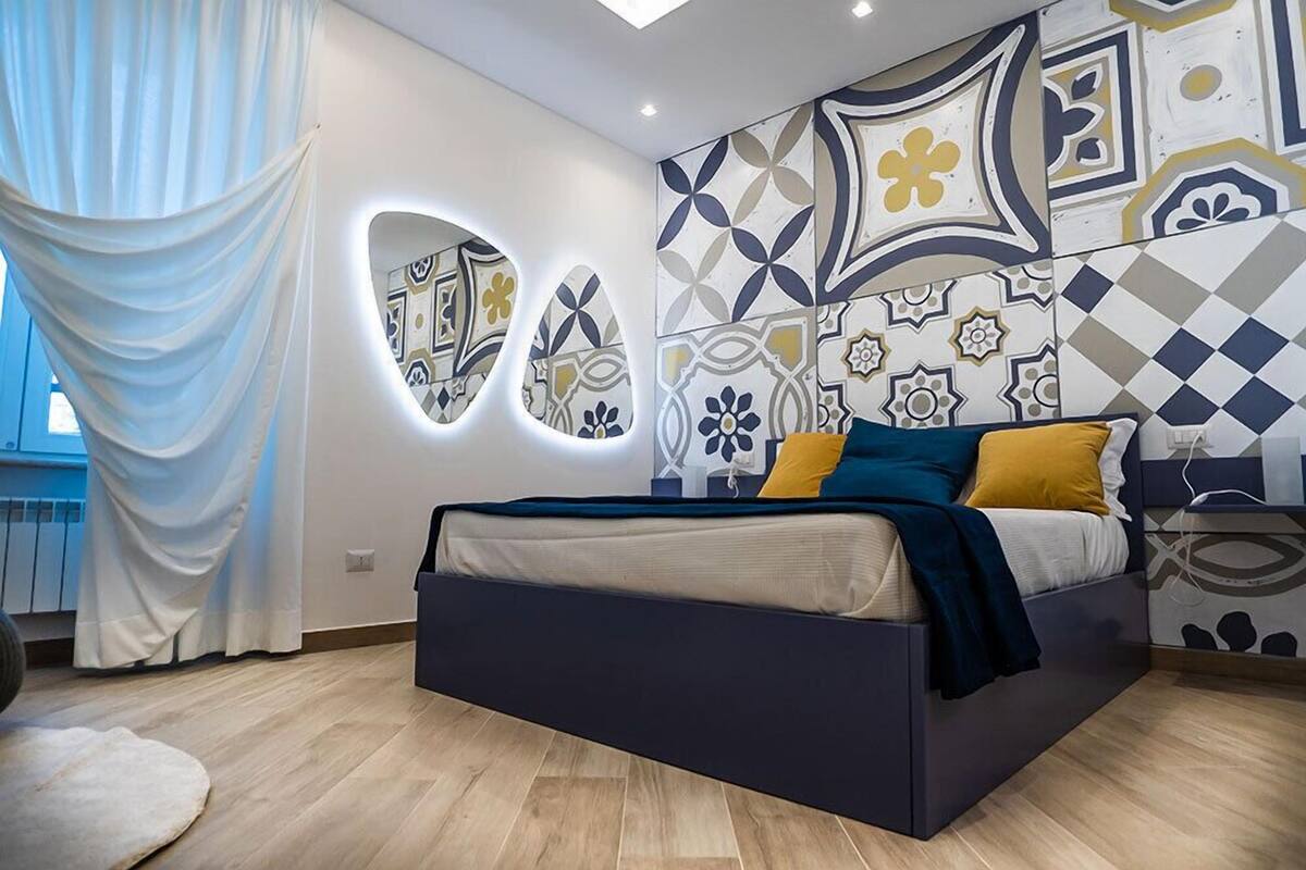 Quarto moderno com cama, cortinas, decoração de parede estampada e design de teto exclusivo.