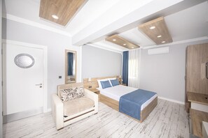 Um quarto moderno com cama, sofá, espelho e guarda-roupa.