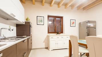 Apartamento, 3 quartos | Cozinha privada | Geladeira, micro-ondas (mediante solicitação), fogão, cooktop