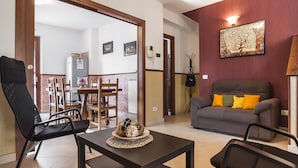 Uma sala de estar com sofá, cadeiras e um espaço de jantar com mesa e cadeiras.