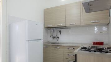 Apartamento, 2 quartos | Kitchenette privada | Um frigorífico, uma placa de cozinha, utensílios de cozinha
