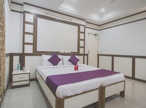 Quarto de hotel bem arrumado com uma cama, uma mesa de cabeceira e um guarda-roupa.