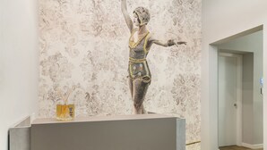 Uma receção com design moderno, parede estampada e chão de madeira.